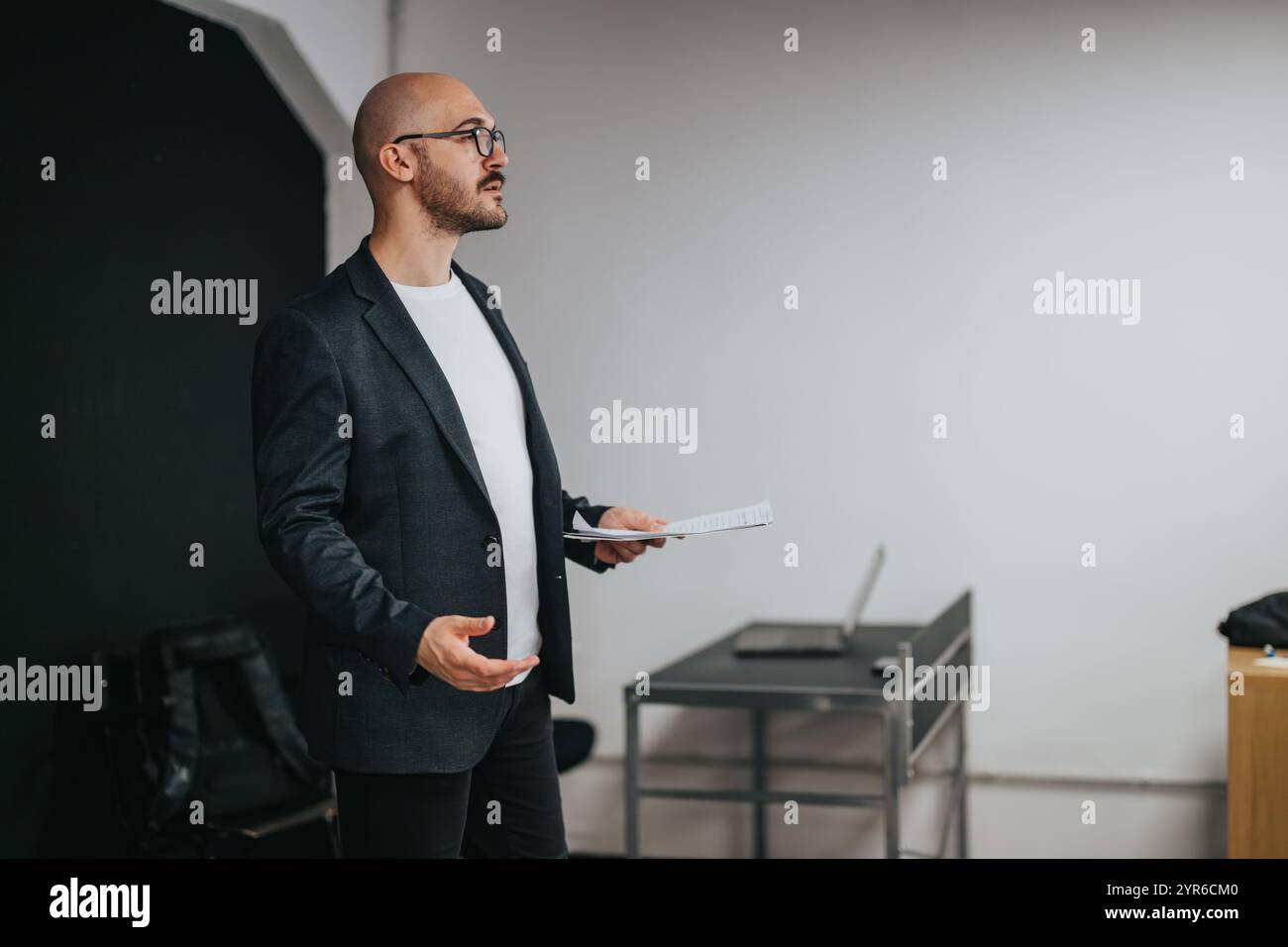Confident teacher giving a lecture in modern classroom setting Stock ...