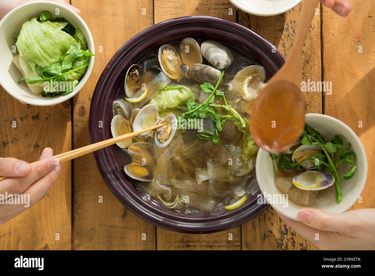 Eating Japanese-style one-pot dish of asari clam and Japanese parsley ...