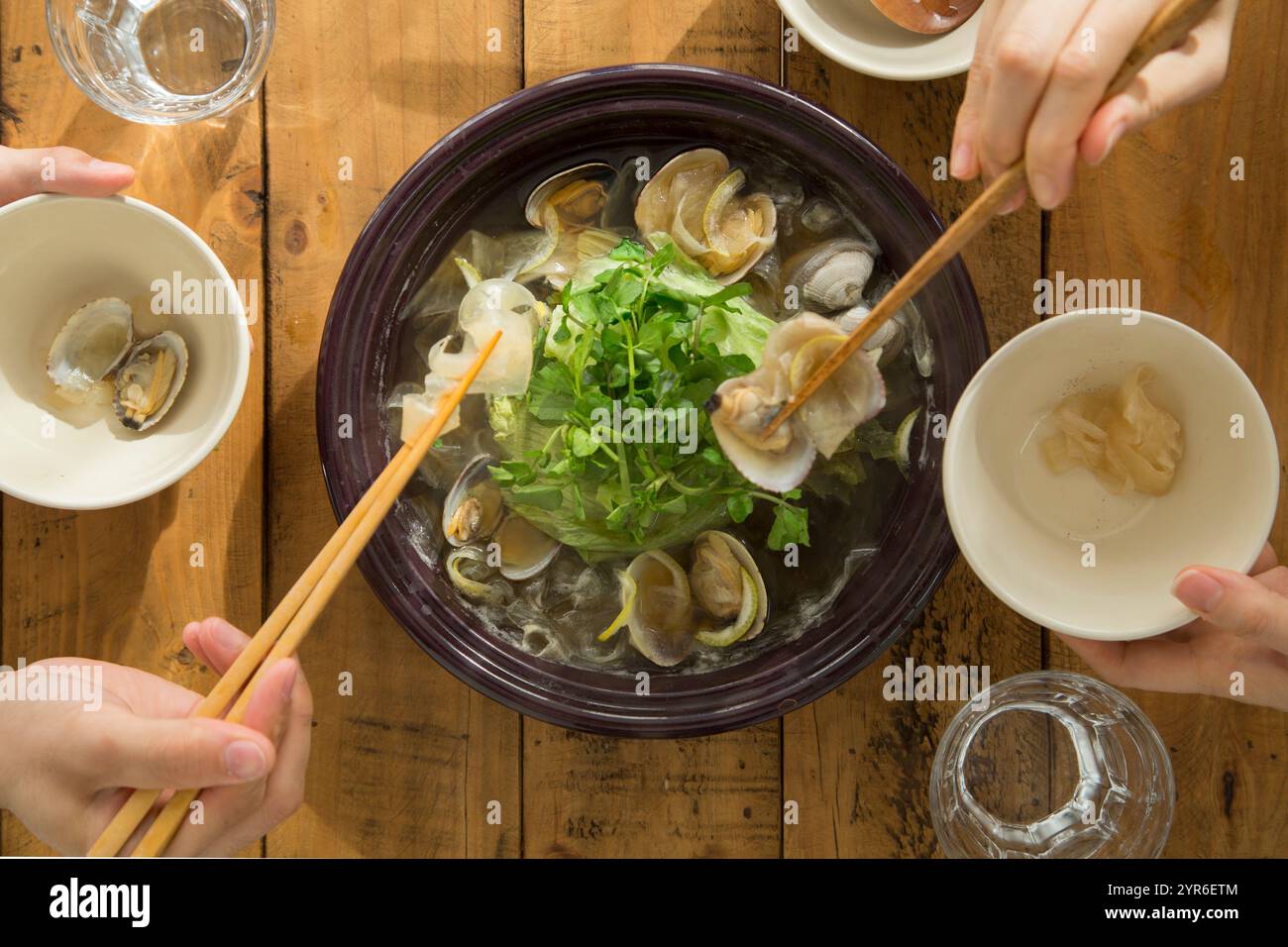 Eating Japanese-style one-pot dish of asari clam and Japanese parsley ...