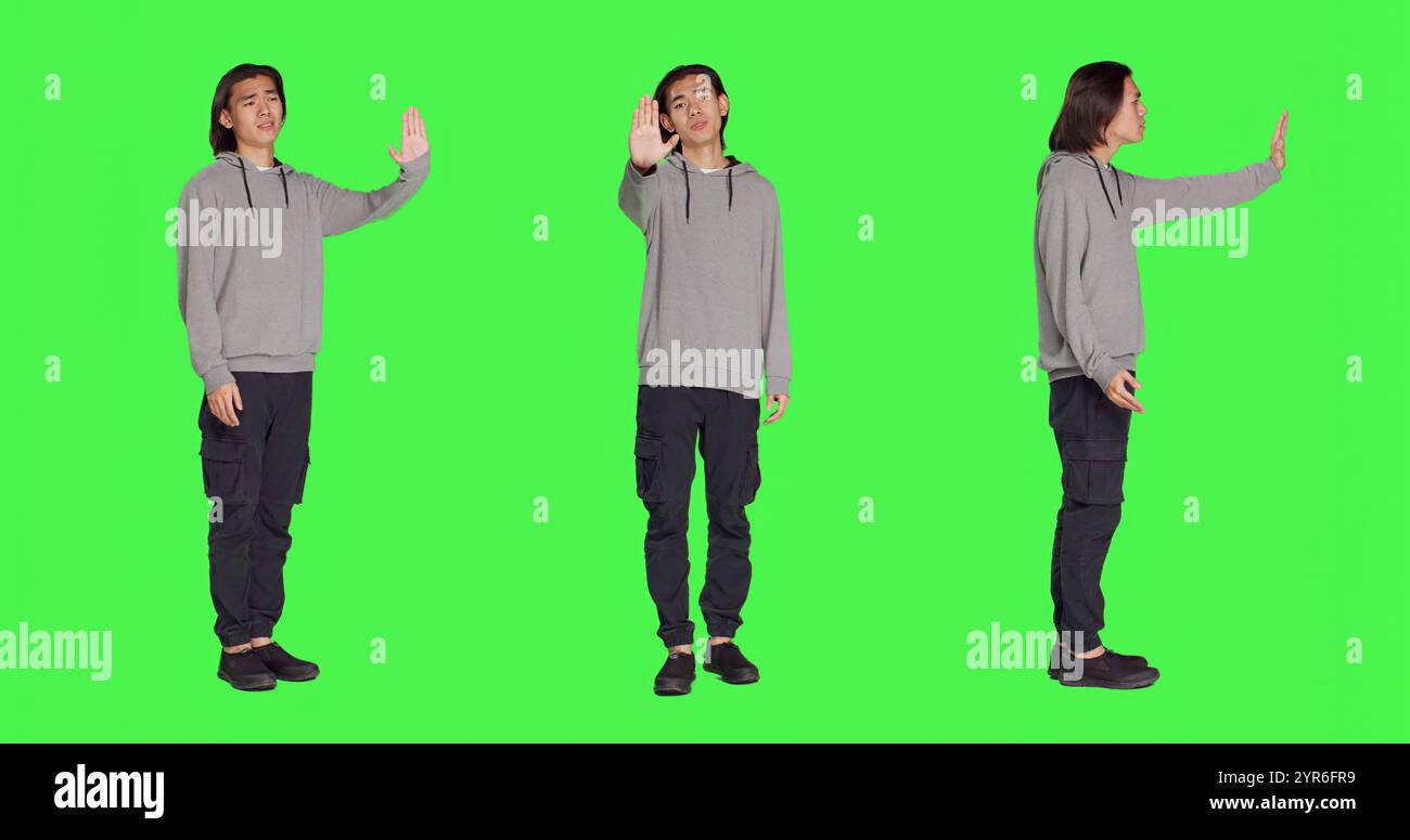 Person showing stop sign with palm raised in studio with greenscreen ...