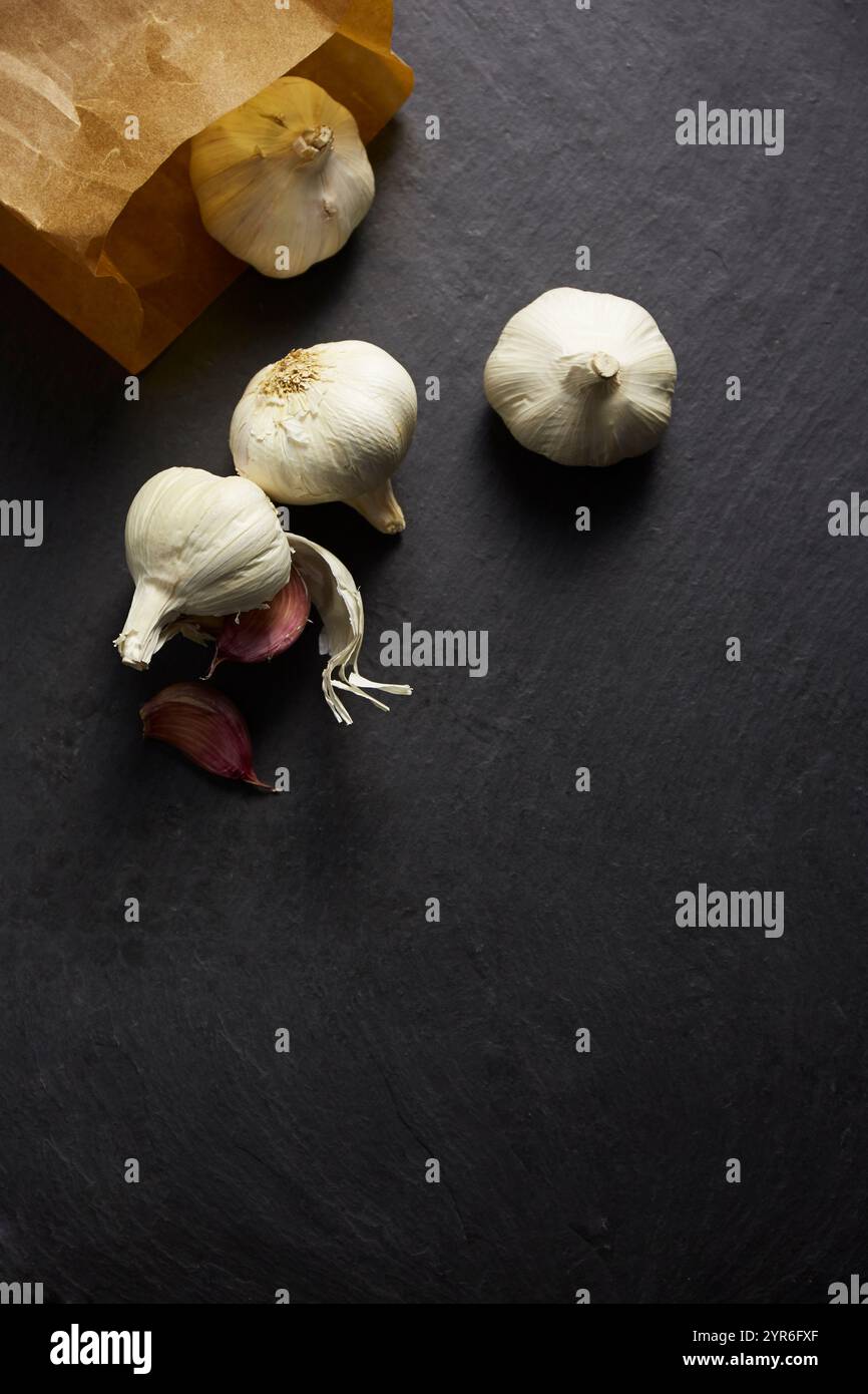 Purple garlic rolled out of a bag on a stone baking sheet Stock Photo ...