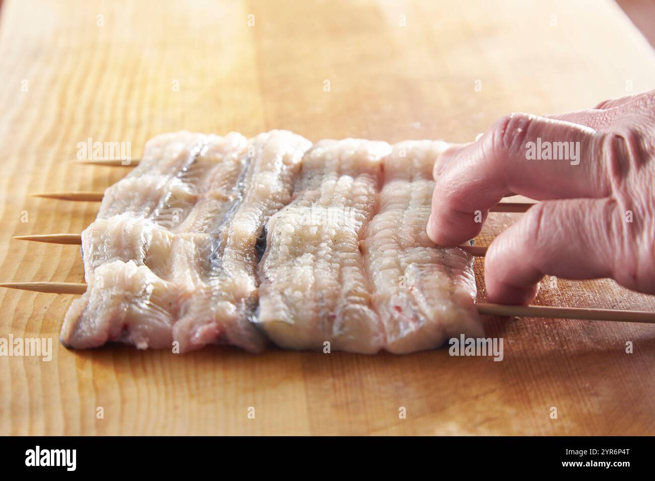 Photo of the process of skewering an eel Stock Photo - Alamy