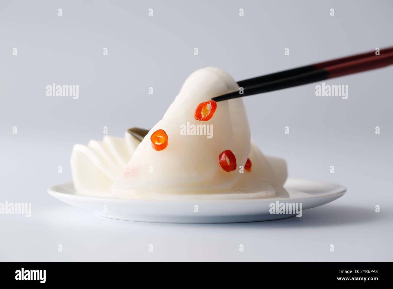 Daikon amazu senmaizuke pickled radish (white background) being lifted ...
