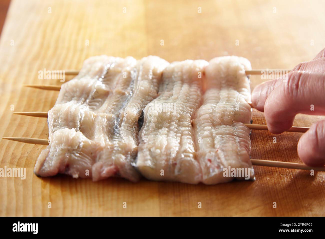 Photo of the process of skewering the eel Stock Photo - Alamy