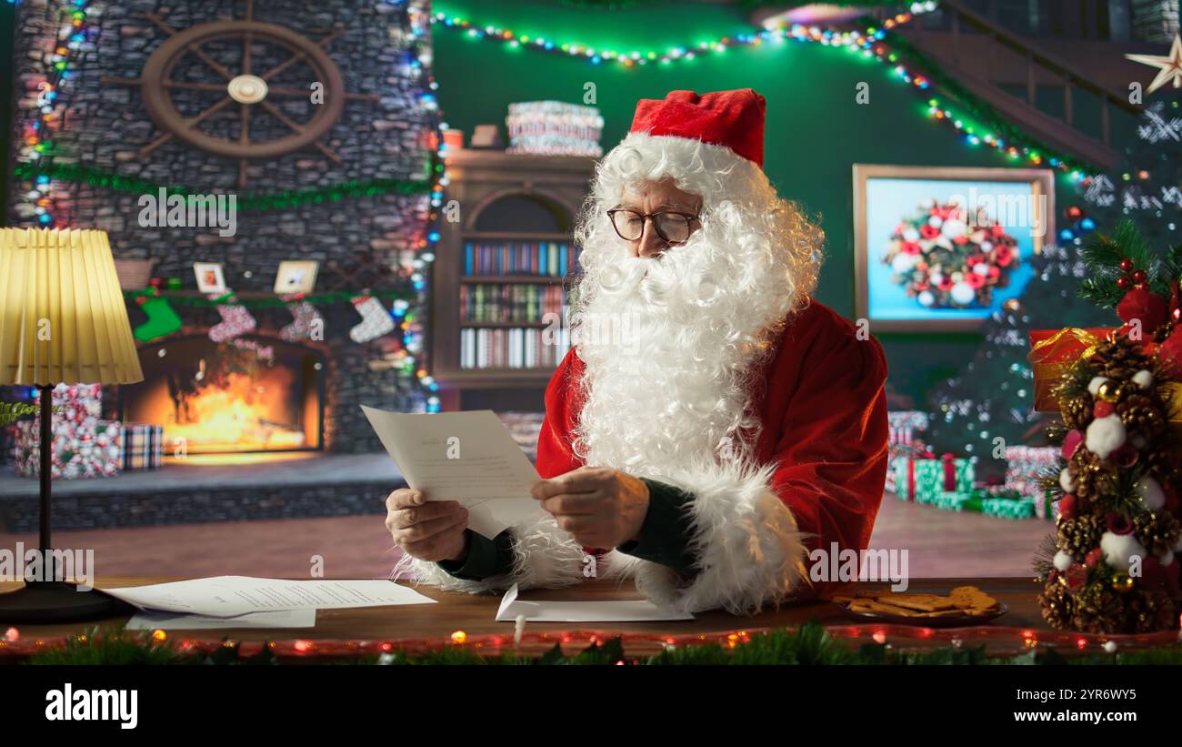 Portrait of cheerful Father Christmas reading letters by the fire ...