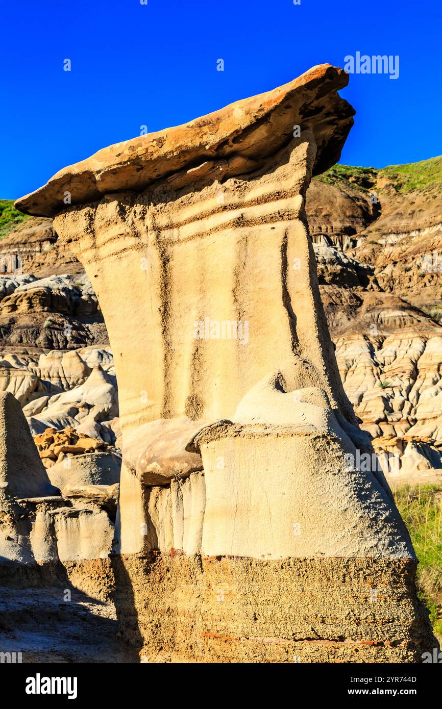 A large rock formation with a pointed top. The rock is brown and has a ...