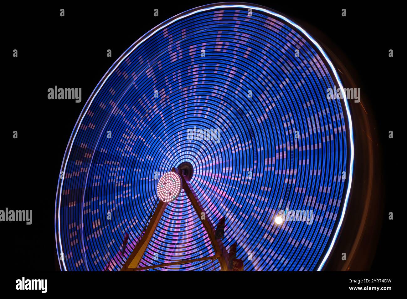 A large blue wheel with a bright light on it. The wheel is spinning and ...