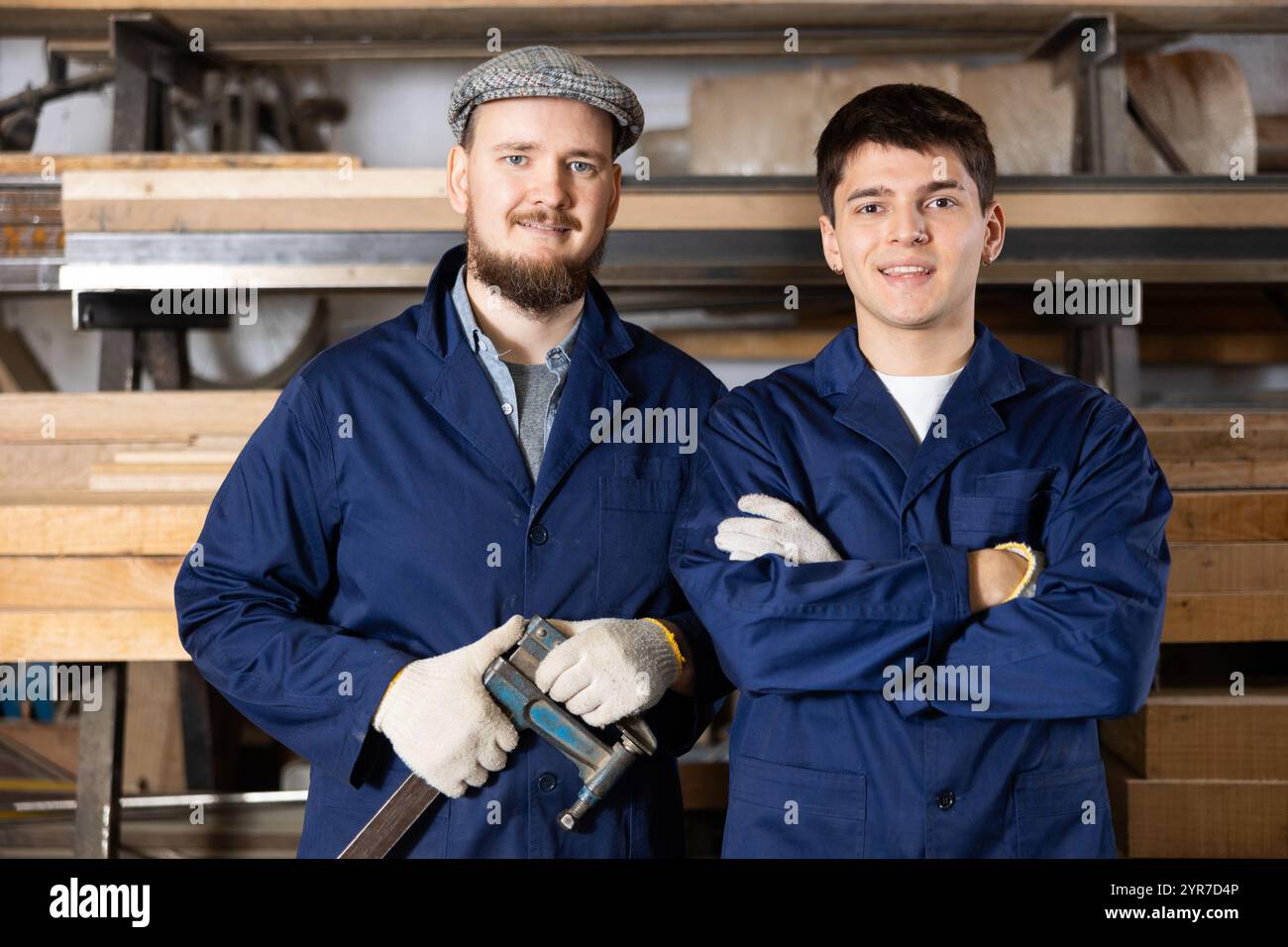 Portrait of two carpenters in uniform in the interior of furniture ...