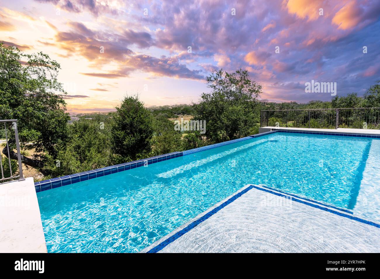 Relaxing by the infinity pool at sunset with beautiful sky and ...