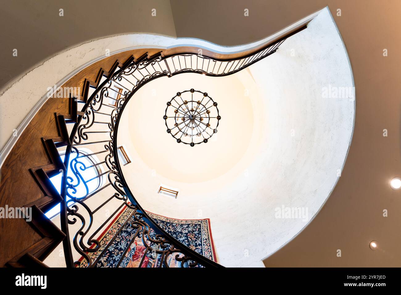 Elegant spiral staircase leading to a bright, inviting upper level ...