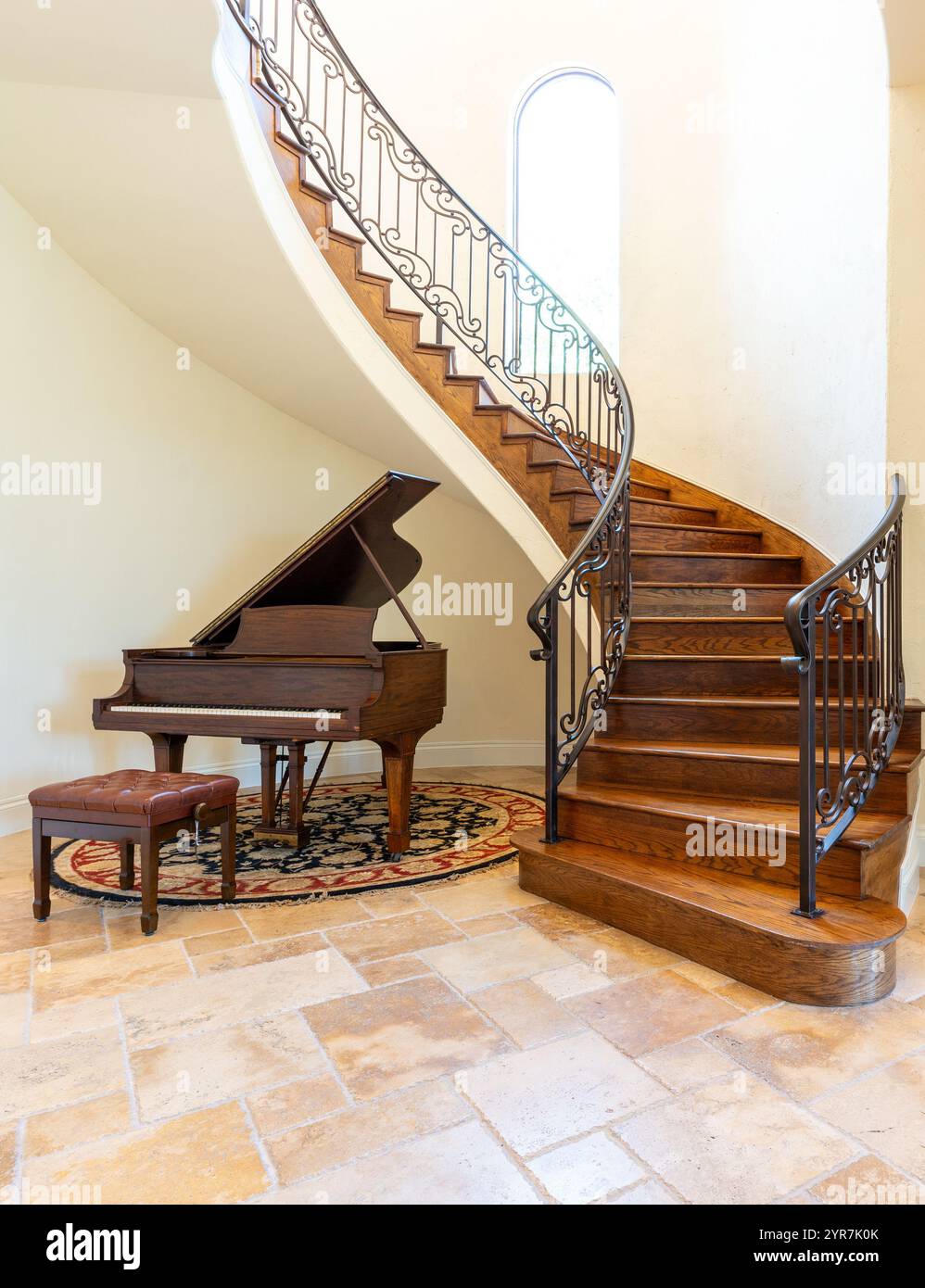 Elegant grand piano beside a graceful spiral staircase in a cozy ...