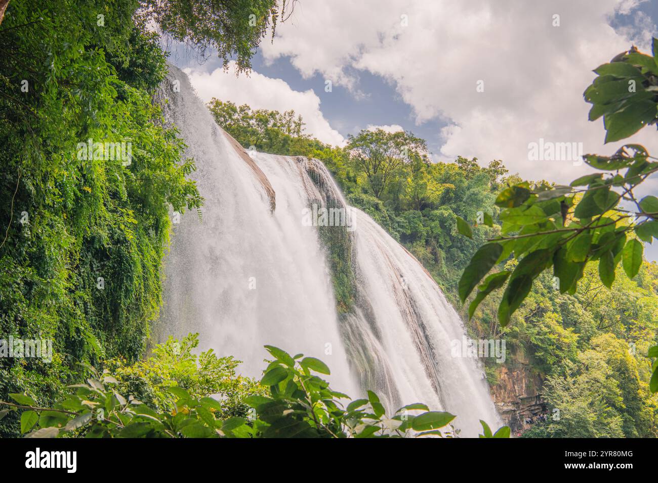 The waterfall interrupts violently the peaceful continuous flow of the ...