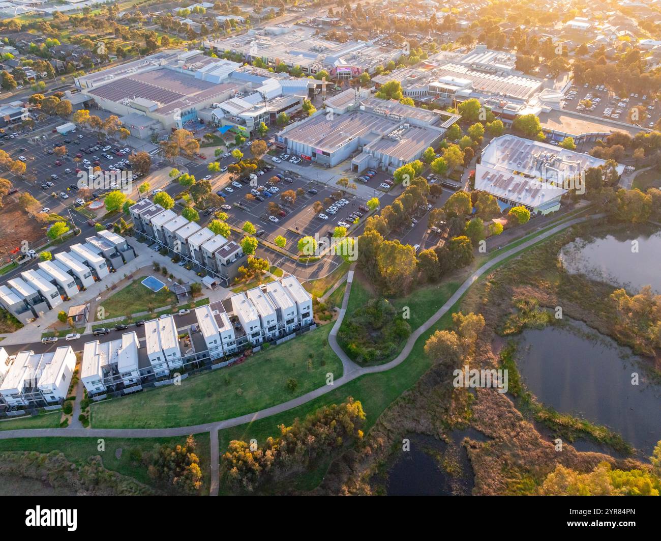 Aerial view of a row of apartments alongside a suburban wetland with ...