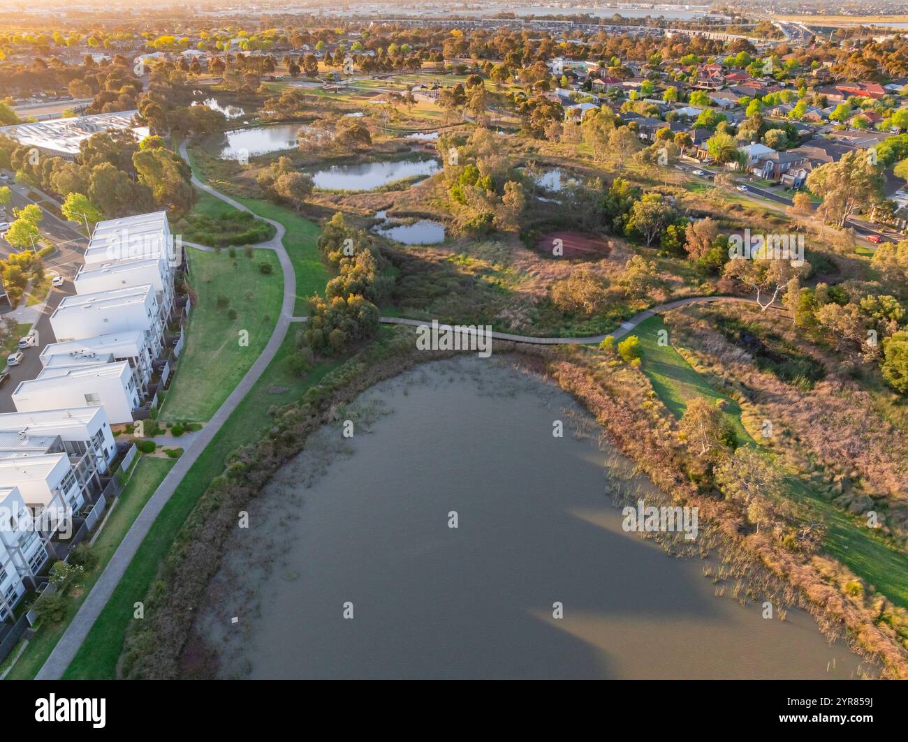 Aerial view of a row of apartments alongside a suburban wetland with ...