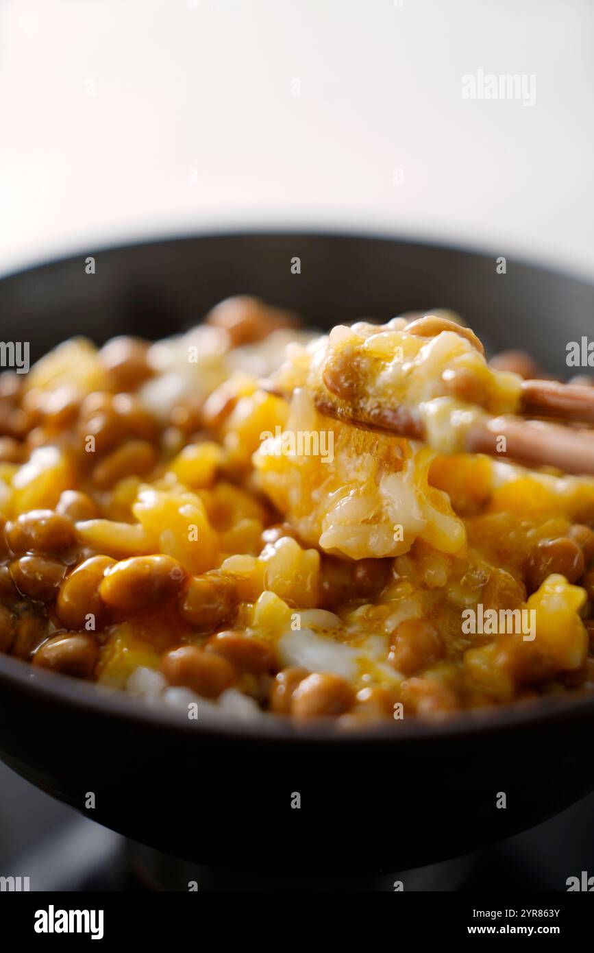 Natto and egg rice with natto and egg yolk lifted up with chopsticks ...