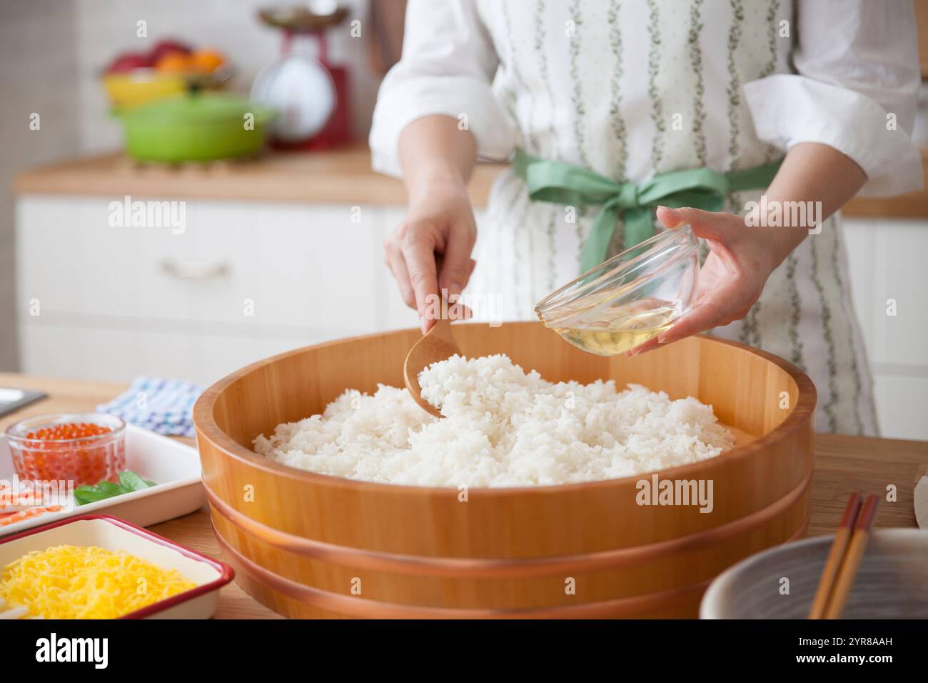 Woman pouring vinegar over rice to make sushi rice Stock Photo - Alamy
