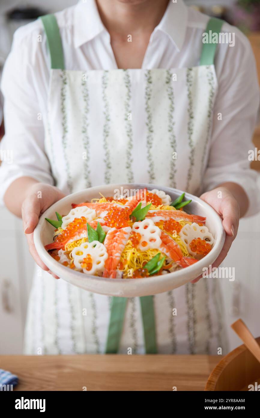 Woman holding plate of cooked chirashi-zushi Stock Photo - Alamy