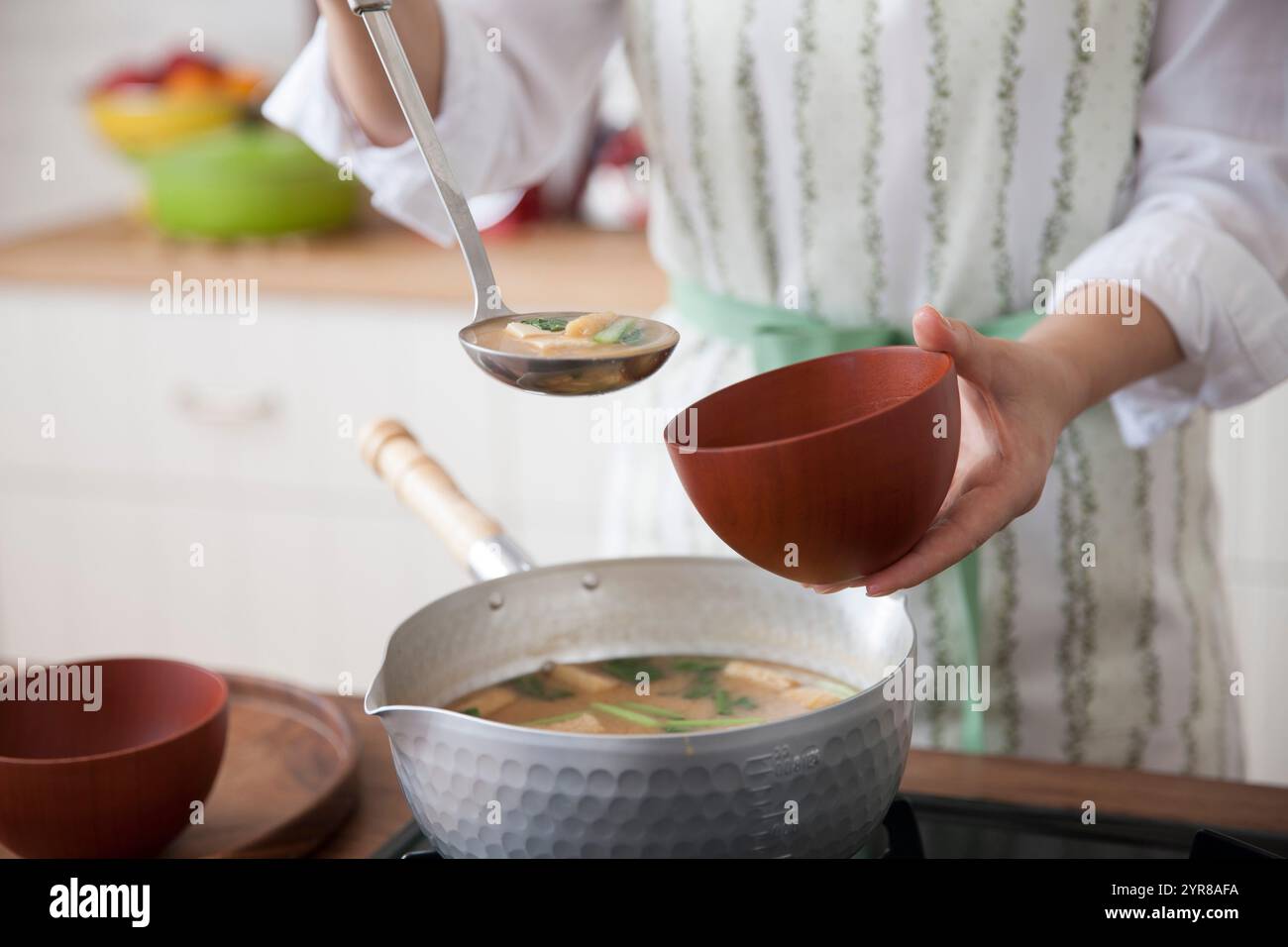 Woman pouring miso soup from a pot into a bowl with a ladle Stock Photo ...