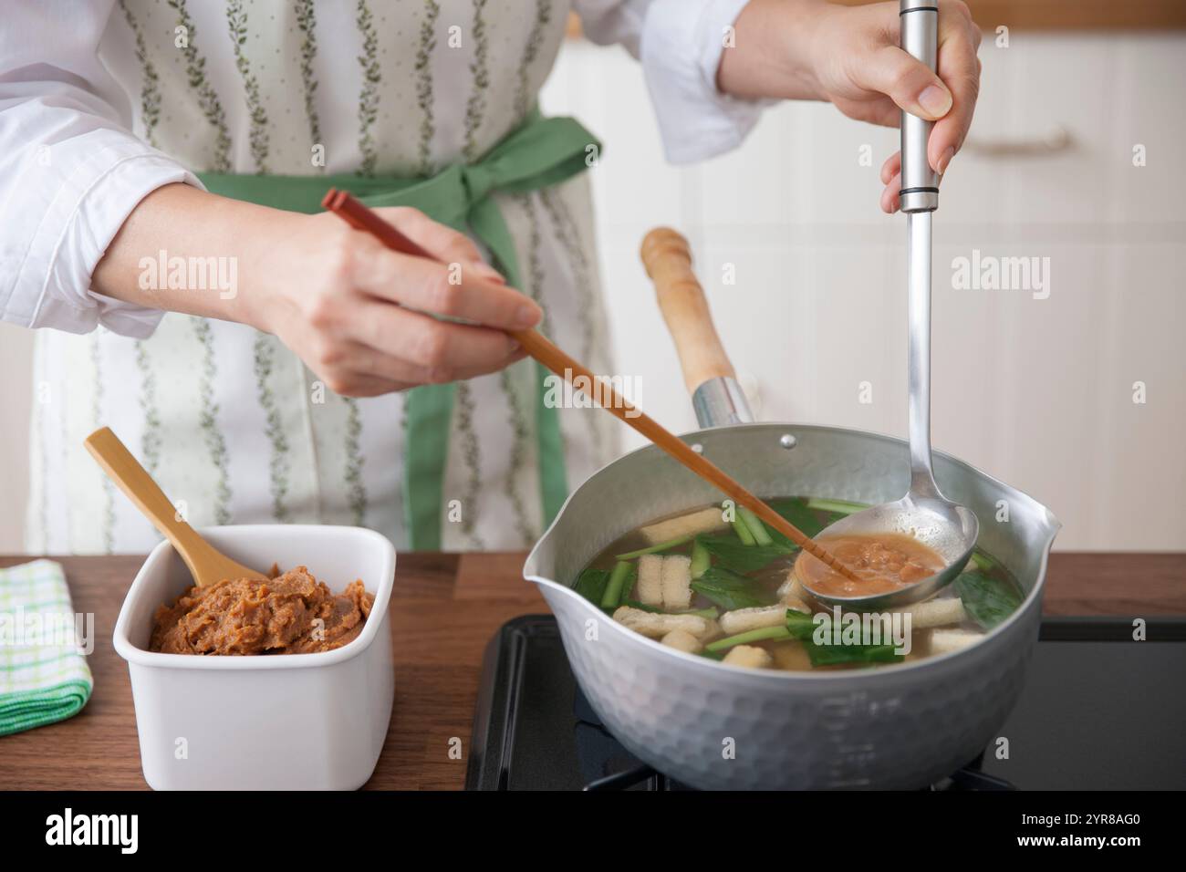 Woman dissolving miso in a pot with a ladle and chopsticks Stock Photo ...