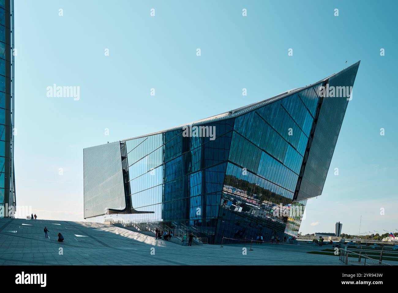 A modern architectural marvel featuring a striking reflective glass ...