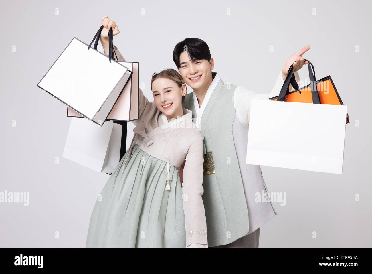 A foreign woman and a young Korean man wearing hanbok and holding ...