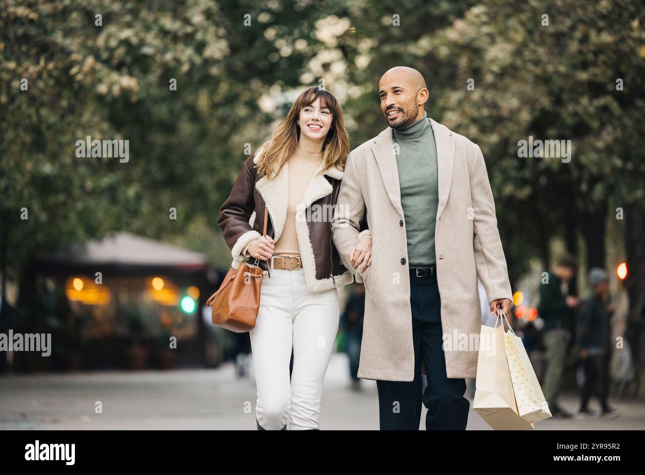 A joyful couple spending quality time shopping together, walking arm in ...