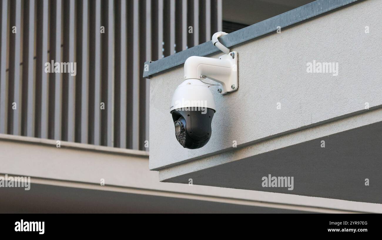 White cctv dome camera providing surveillance at building entrance ...
