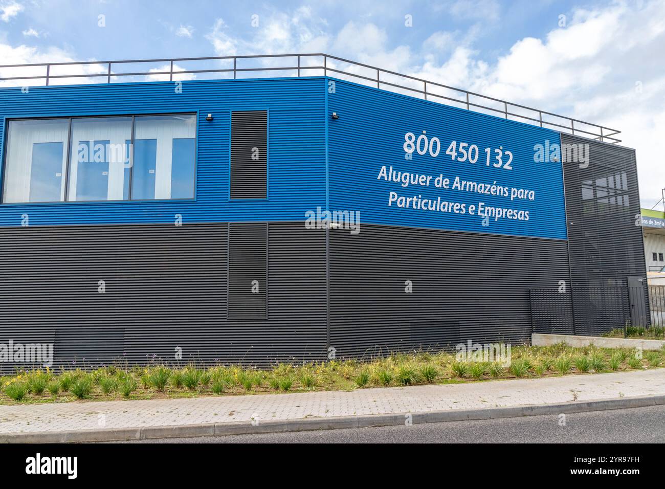 Exterior of a contemporary self storage facility featuring blue and gray metal siding ...