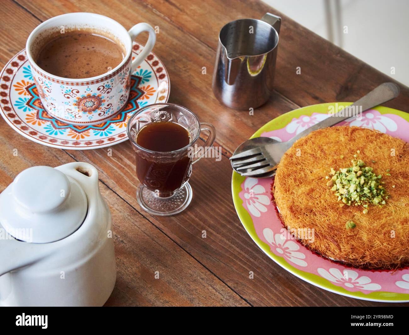 Turkish black coffee surrounded by side dishes in the form of Kunafa, a ...