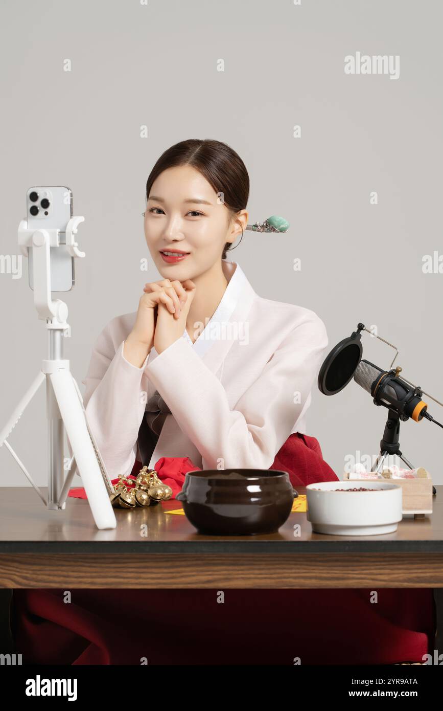A young shaman wearing a hanbok and broadcasting live Stock Photo - Alamy