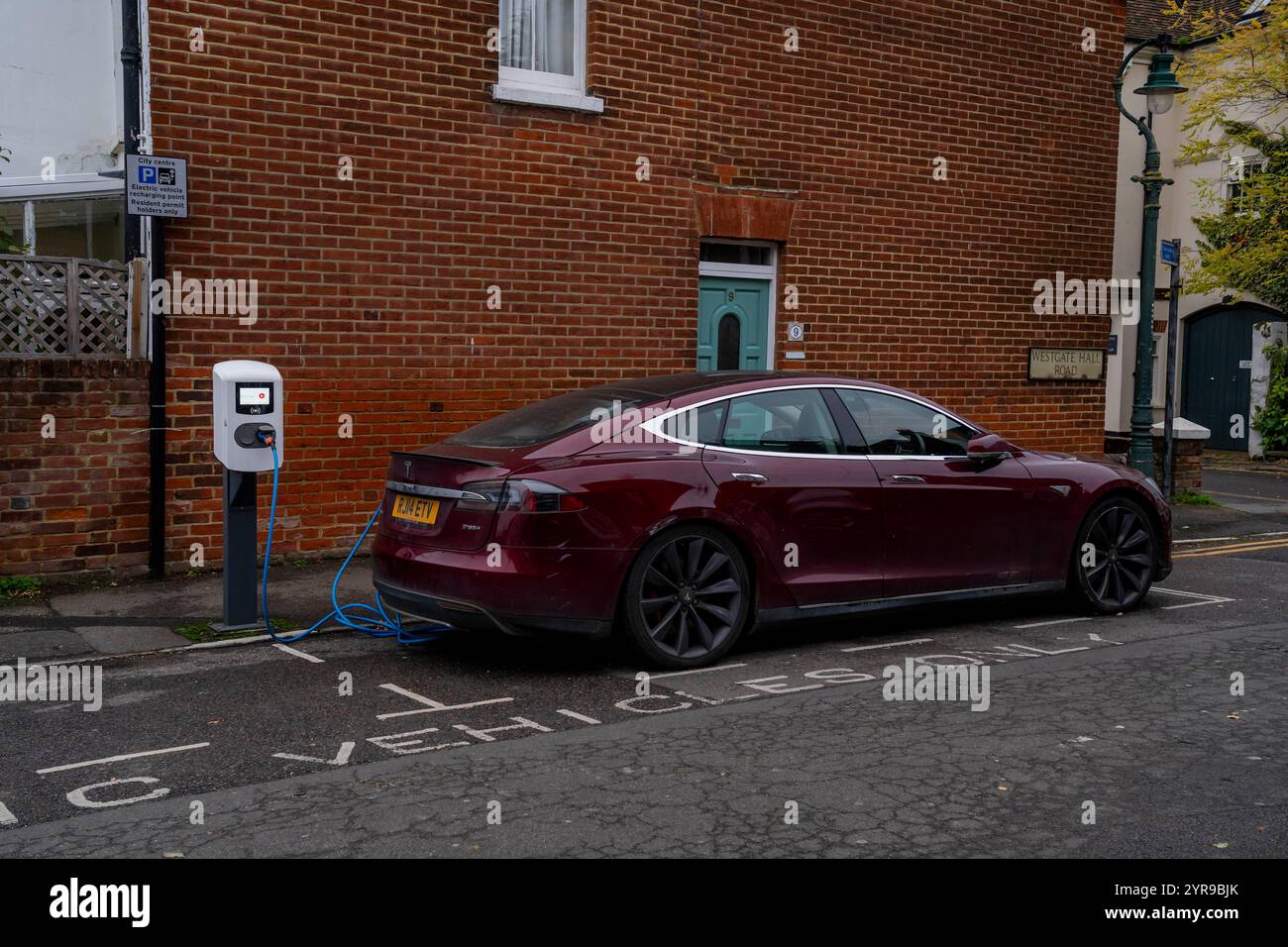 Tesla electric car getting charged in street hi-res stock photography ...