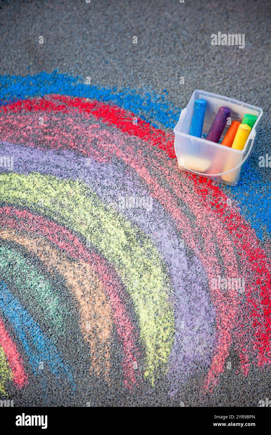 Sidewalk chalk drawing. A rainbow painted on the asphalt. Kids ...