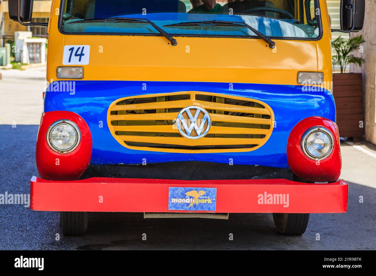 A colorful VW van with a blue, yellow and red stripe. The van is parked ...