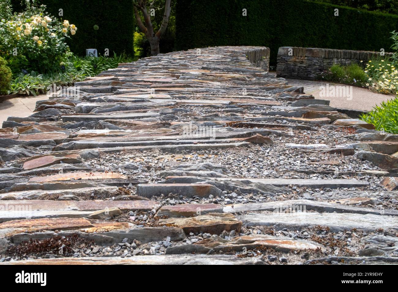 A garden wall made of flint and slate, stone wall, rock wall, RHS Rosemoor Stock Photo - Alamy