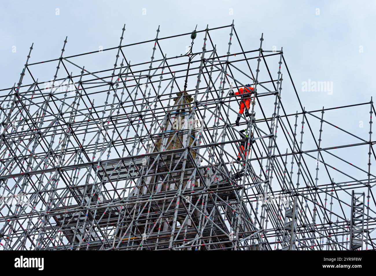 Two skilled workers with safety equipment installing scaffolding at the ...