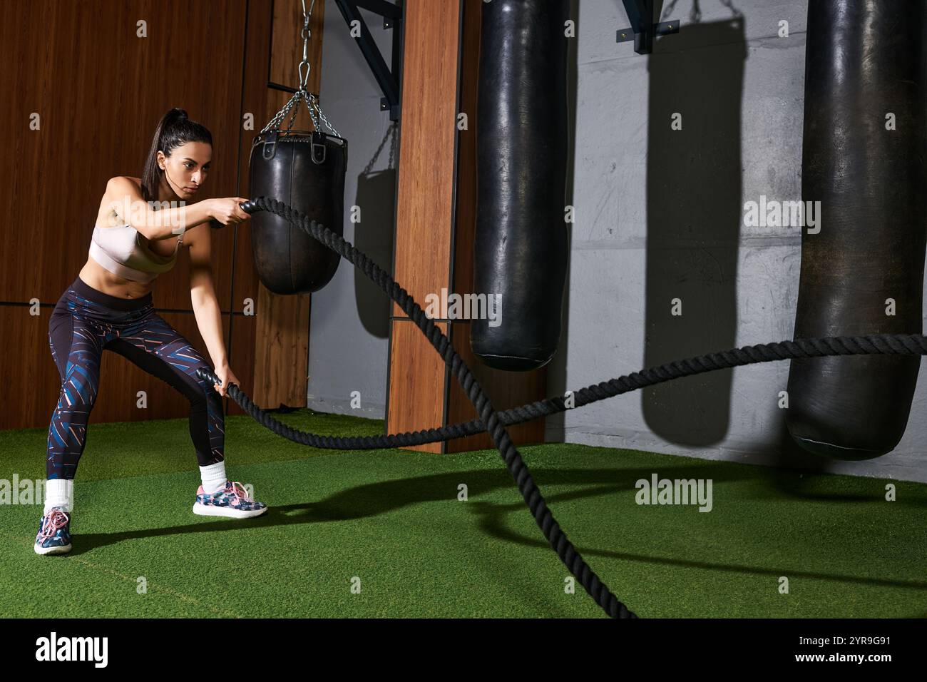 A dedicated woman engages in an intense exercise routine using battle ...