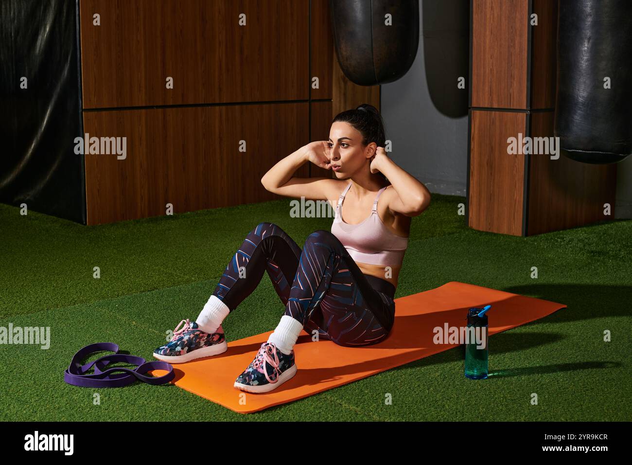 Fitness enthusiast engages in core strengthening exercises on a mat in ...
