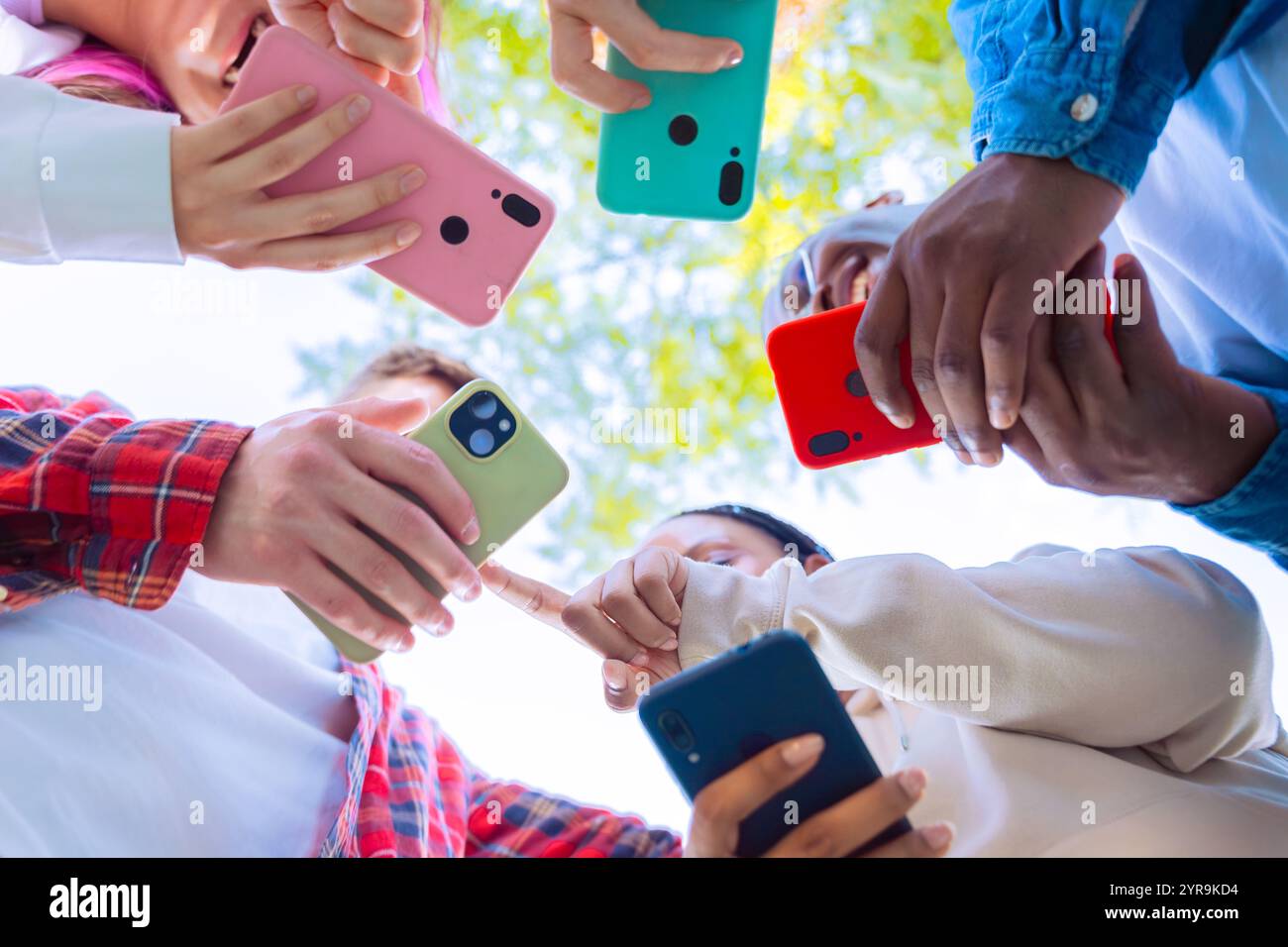 Group of friends holding different smartphones together, showing ...