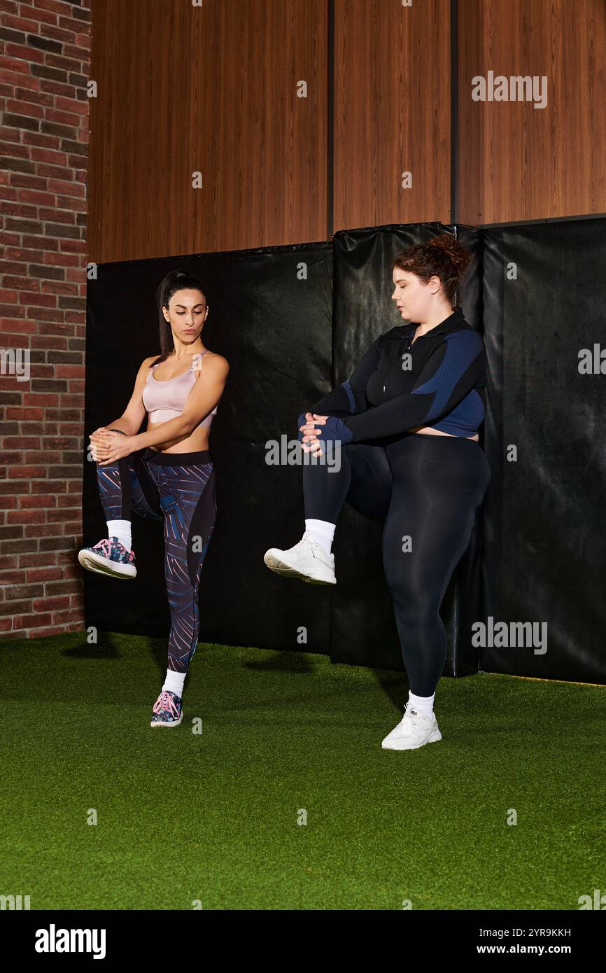 Two women engage in a dynamic stretching routine in a modern gym ...