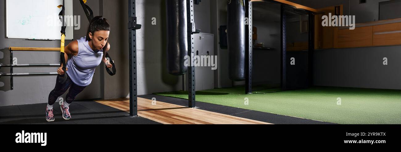 woman performs suspension push ups in a well equipped gym during a ...