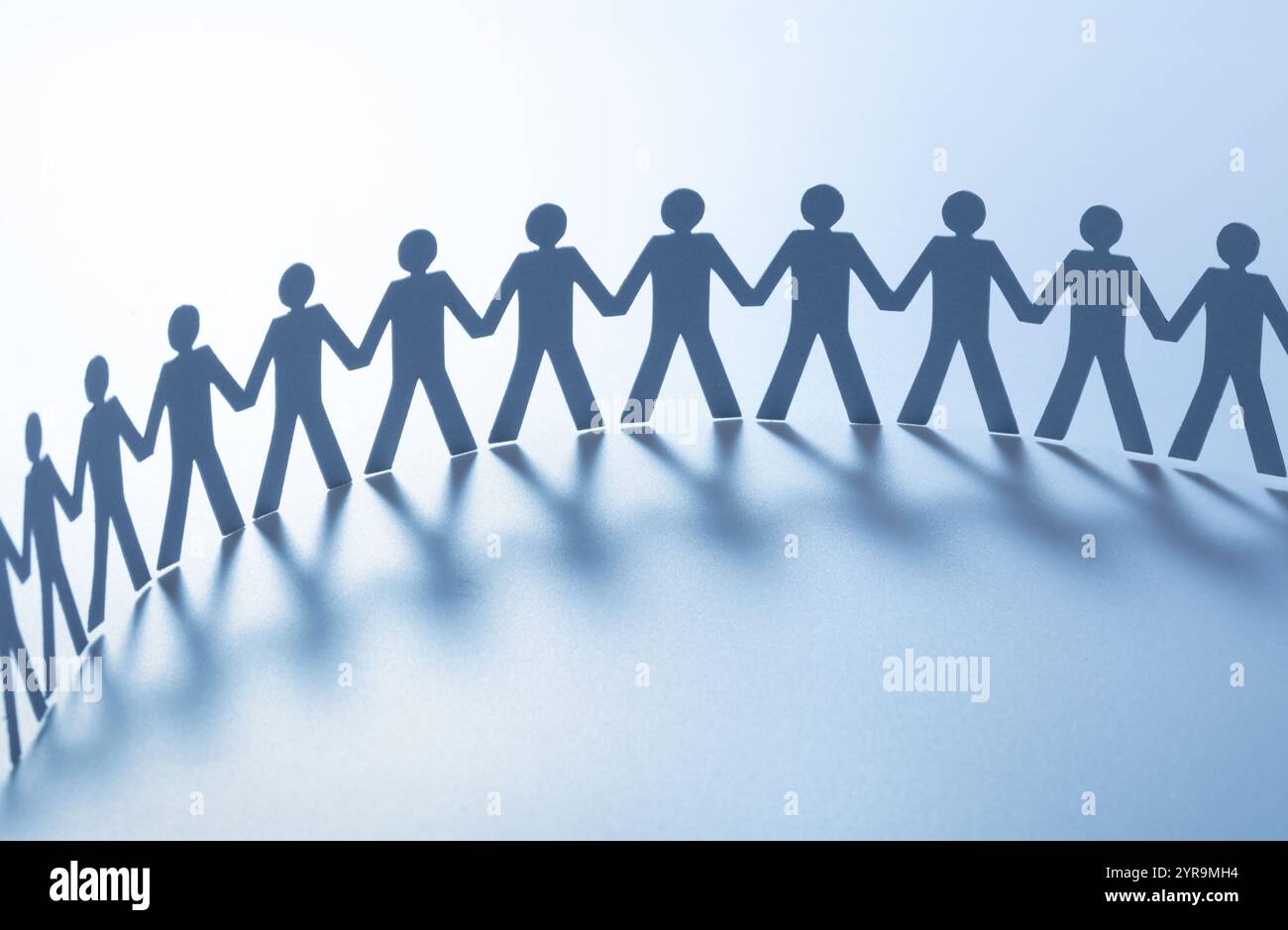 Paper people standing together hand in hand Stock Photo - Alamy