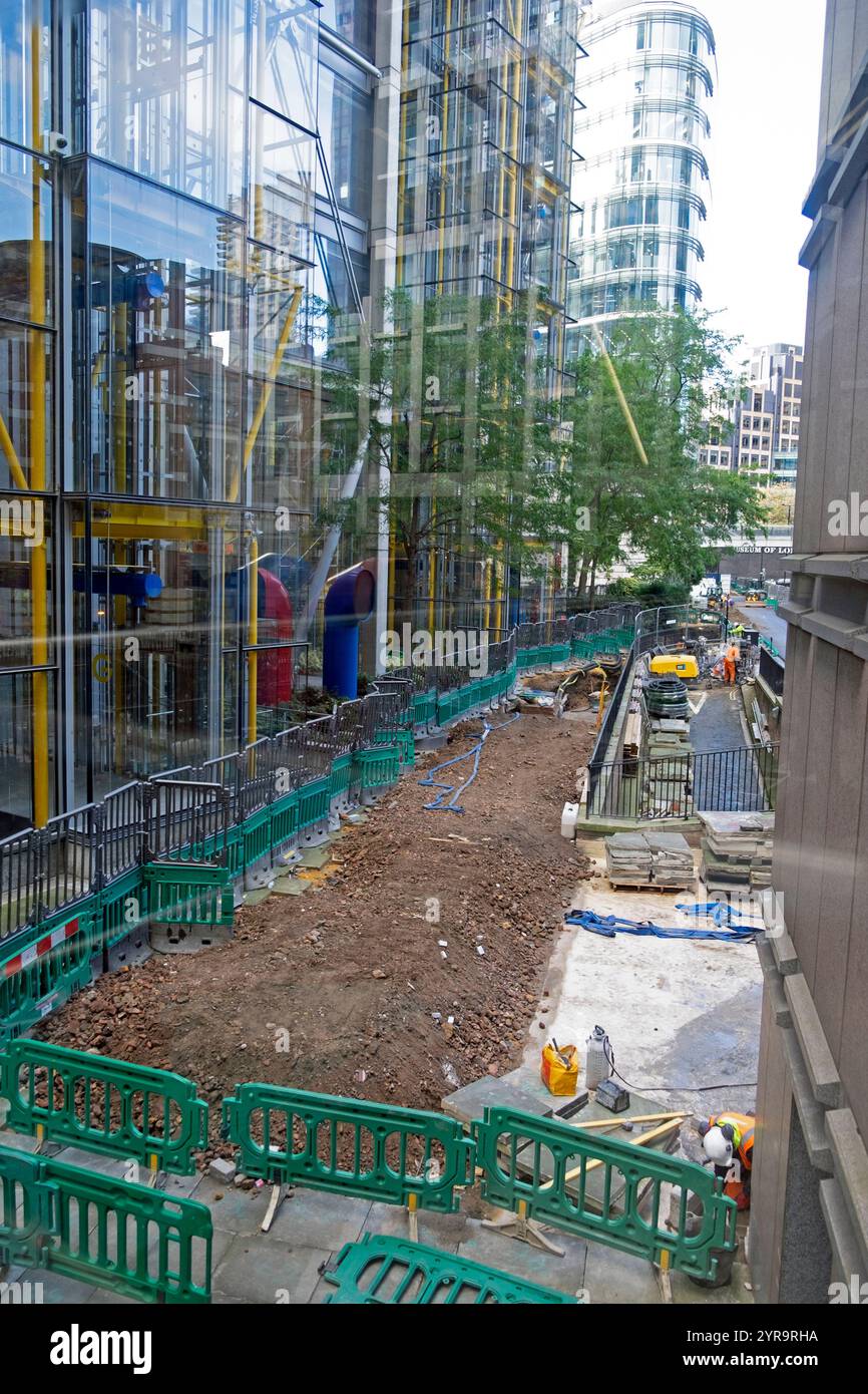 Workers workmen working laying pavement next to LONDON WALL road ...