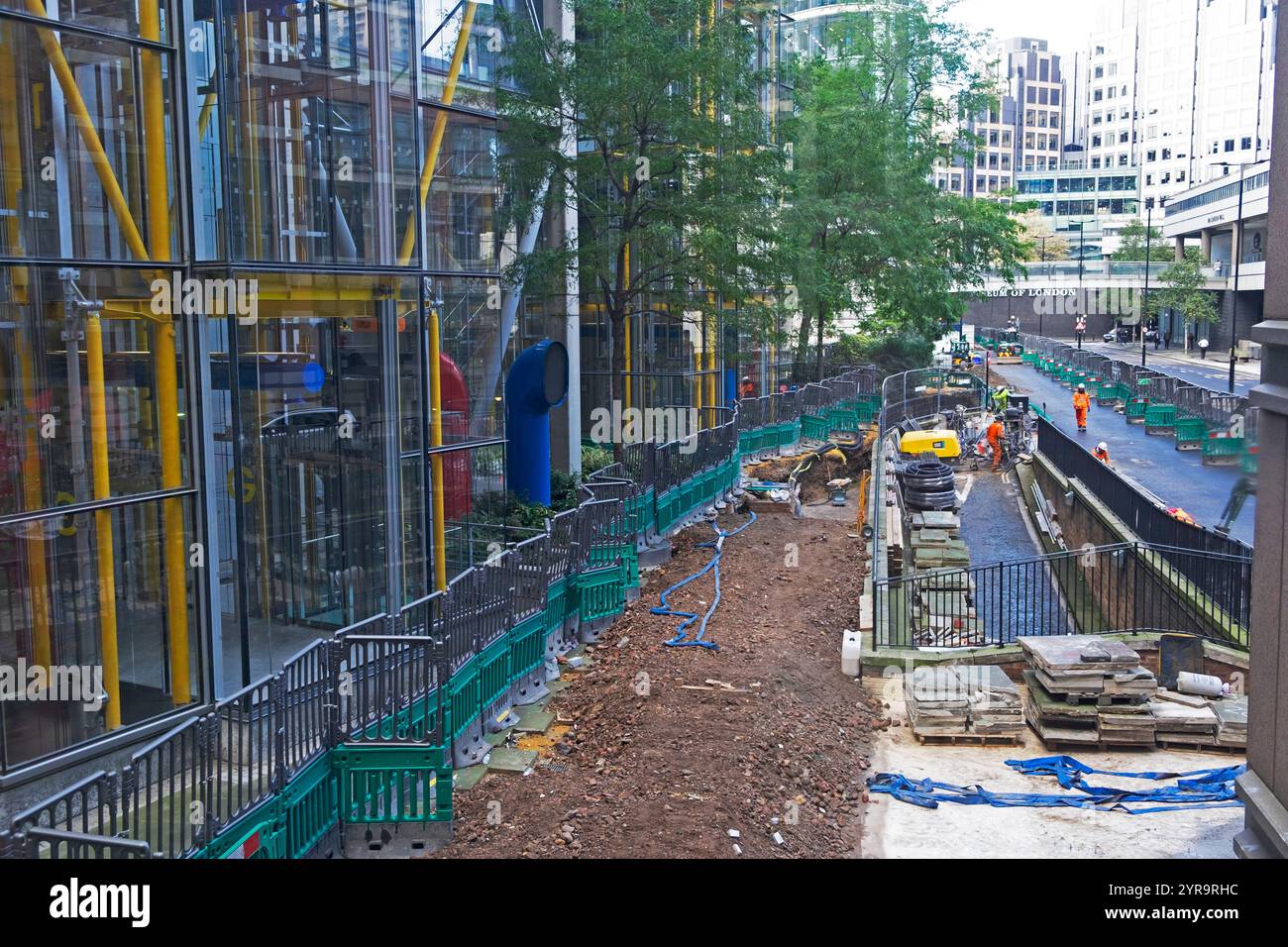 Workers workmen working laying pavement next to LONDON WALL road ...