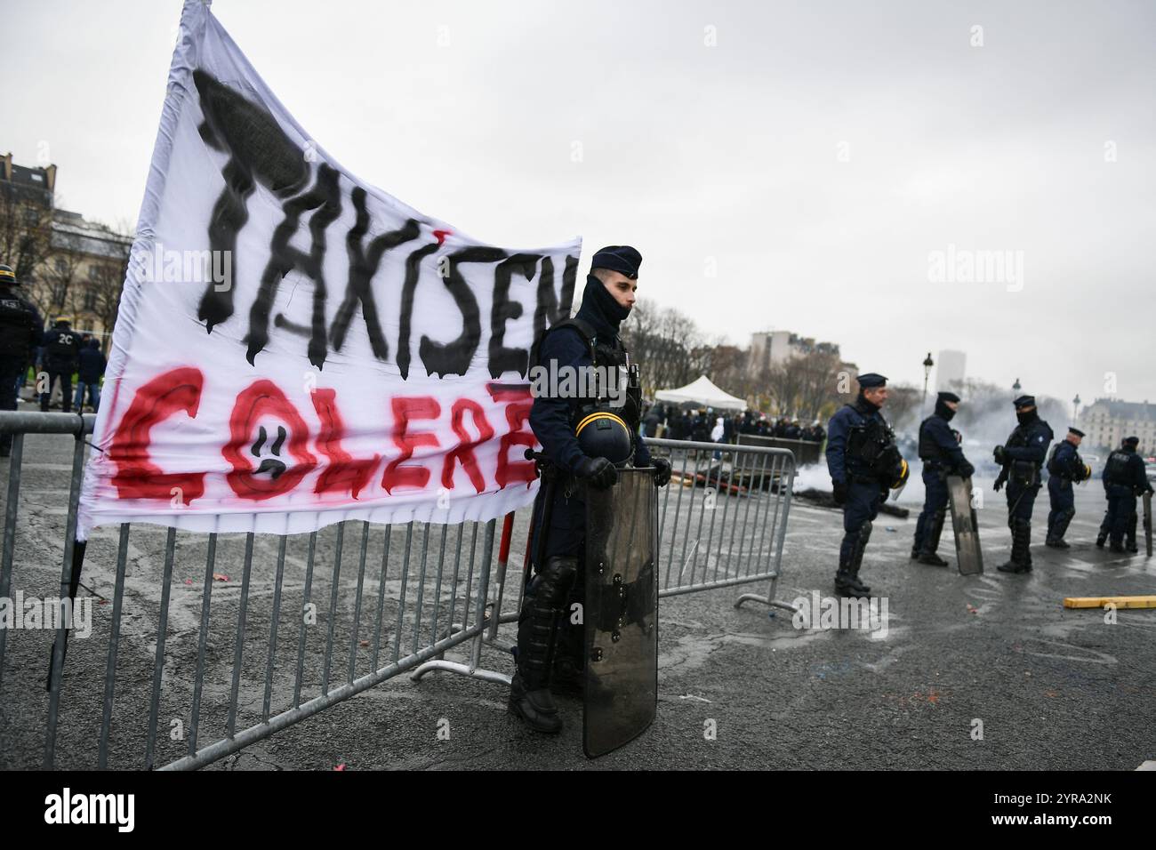 A riot police officer looks on as taxi drivers participate in a ...