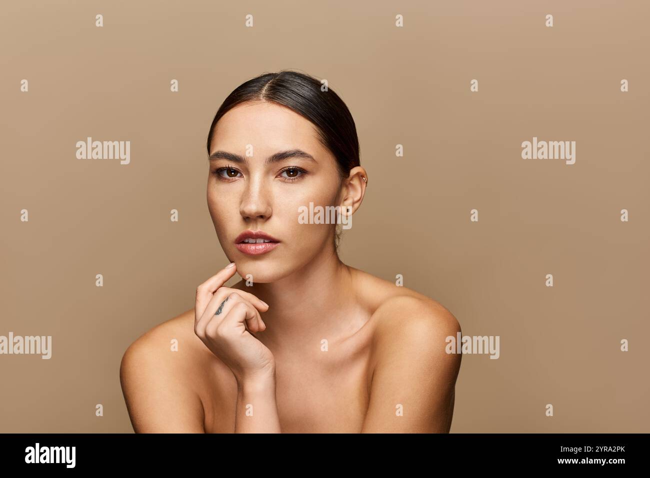 Brunette woman poses elegantly with a gentle expression in a soft ...