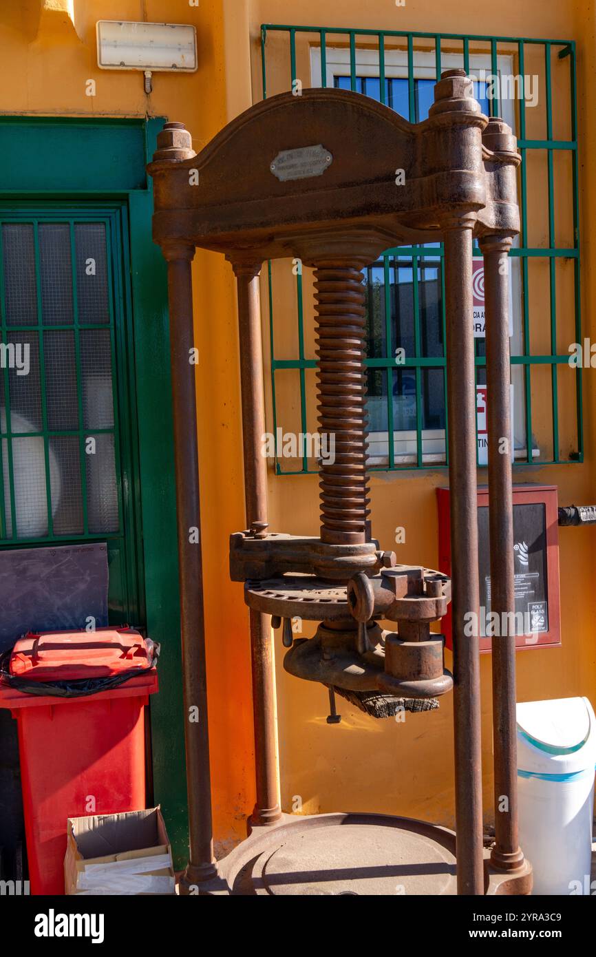 A vintage mechanical screw press for pressing olives on display at an ...