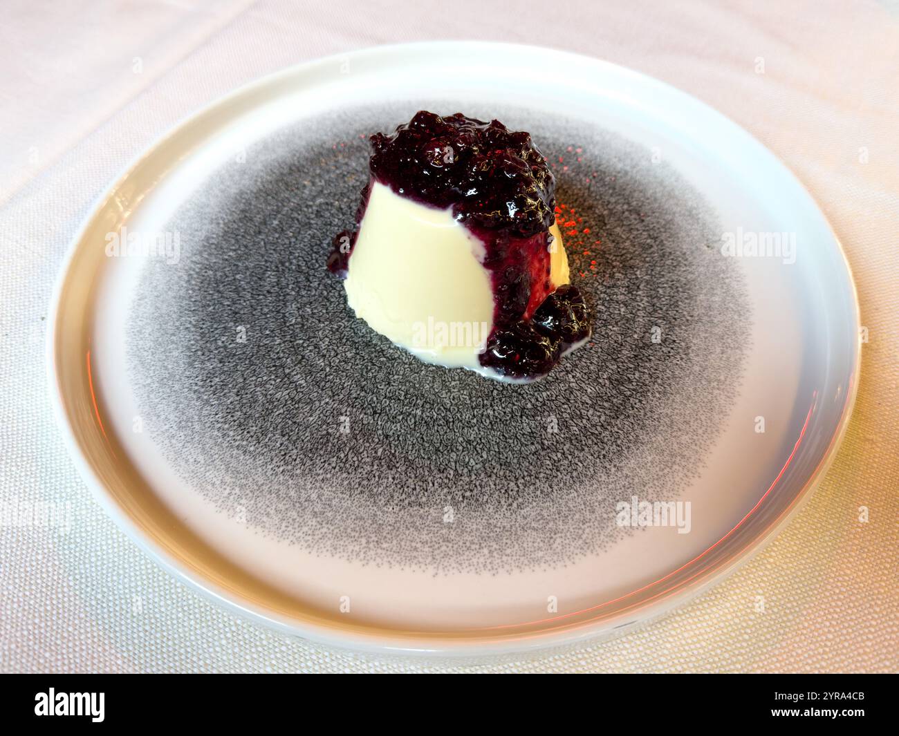 A traditional panna cotta dessert with a mixed berry sauce in a ...