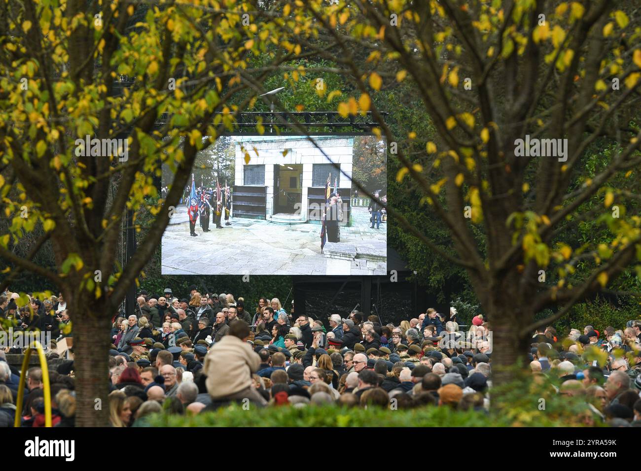 people watching a big screen in queens park on remembrance day in ...