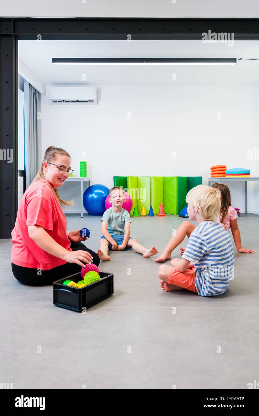 Kids physical therapy. Group of children and female therapist ...