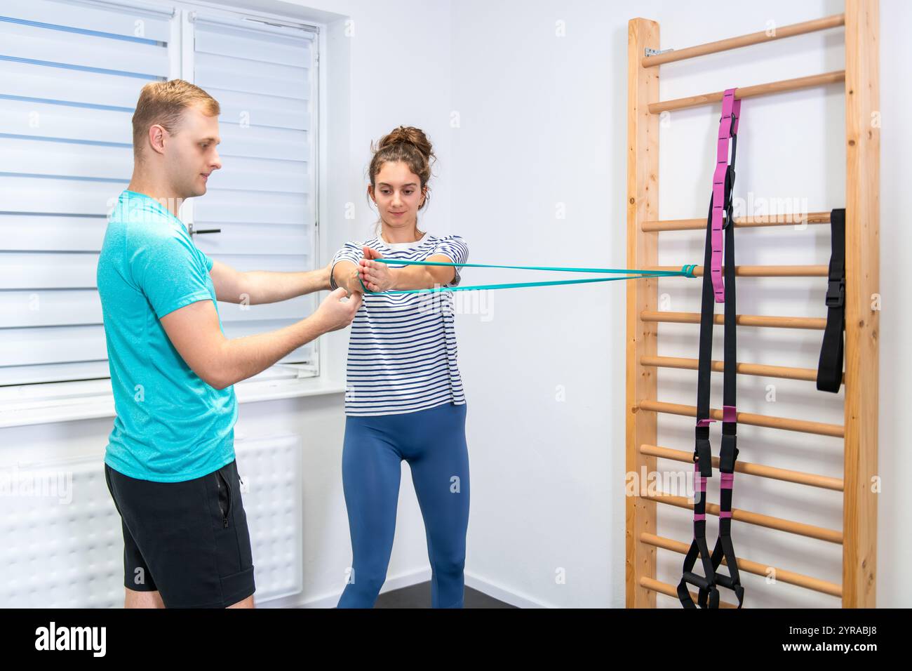 Woman with shoulder pain in physical therapy. Physical therapist exercising with female patient ...